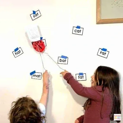 Children engaging in a learning activity with word cards for rhyming ...