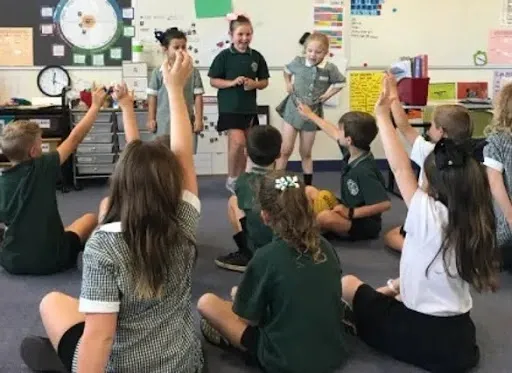 School children engaged in a classroom activity, with some students ...